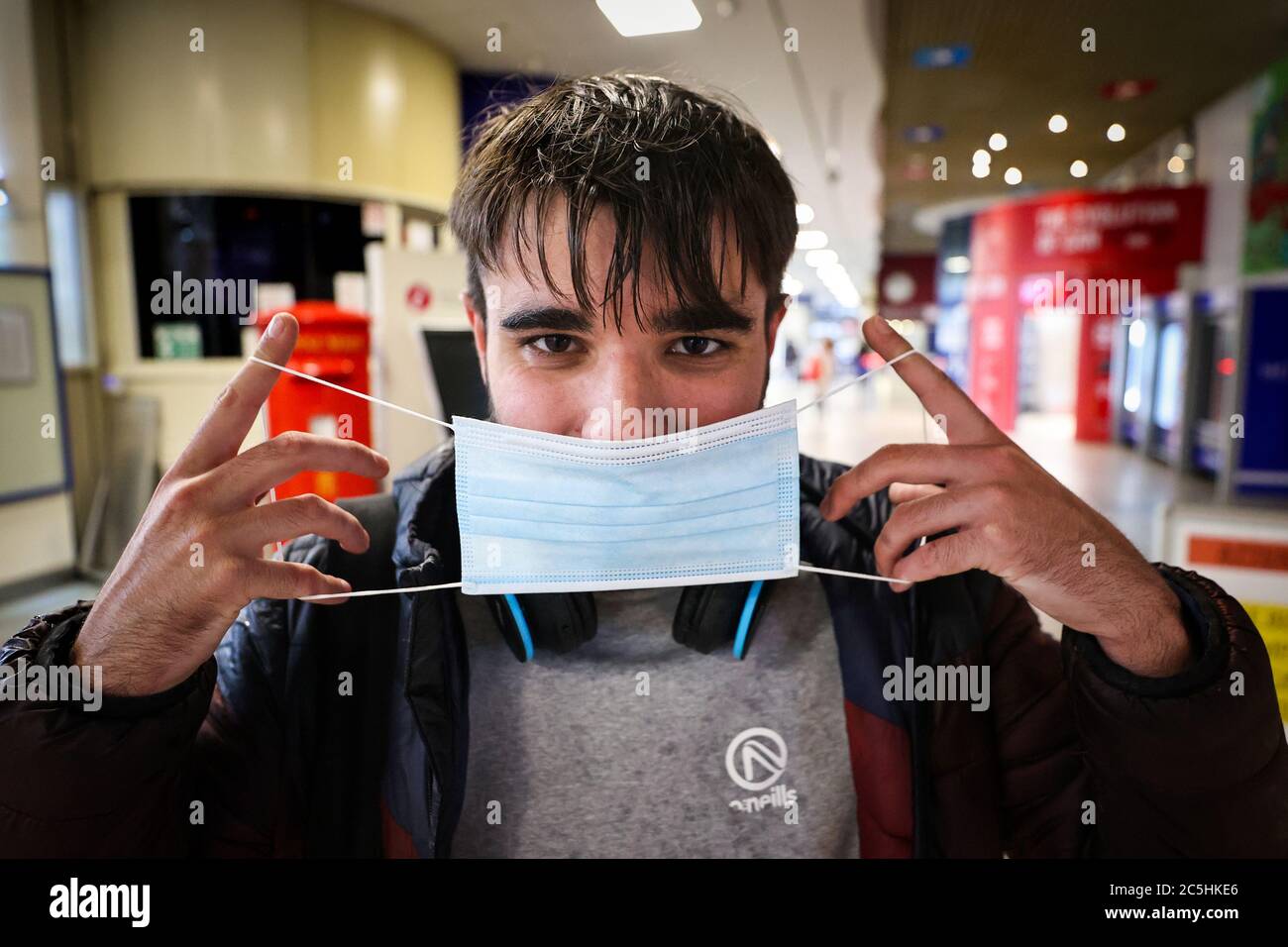 Cathal Murray putting on a face mask he received from Translink ...