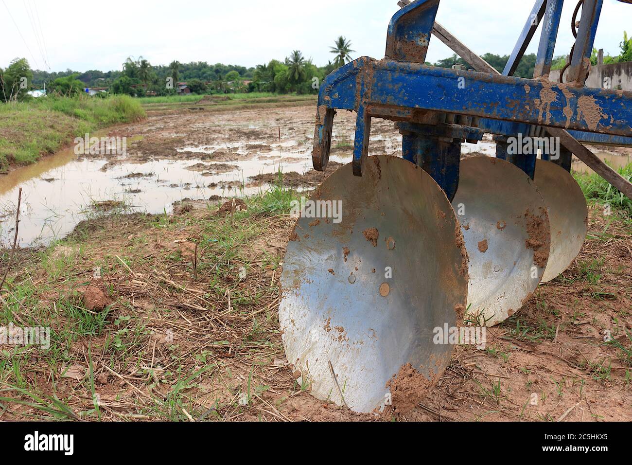 A frame set of three disc plough placed beside the rice fields Stock ...