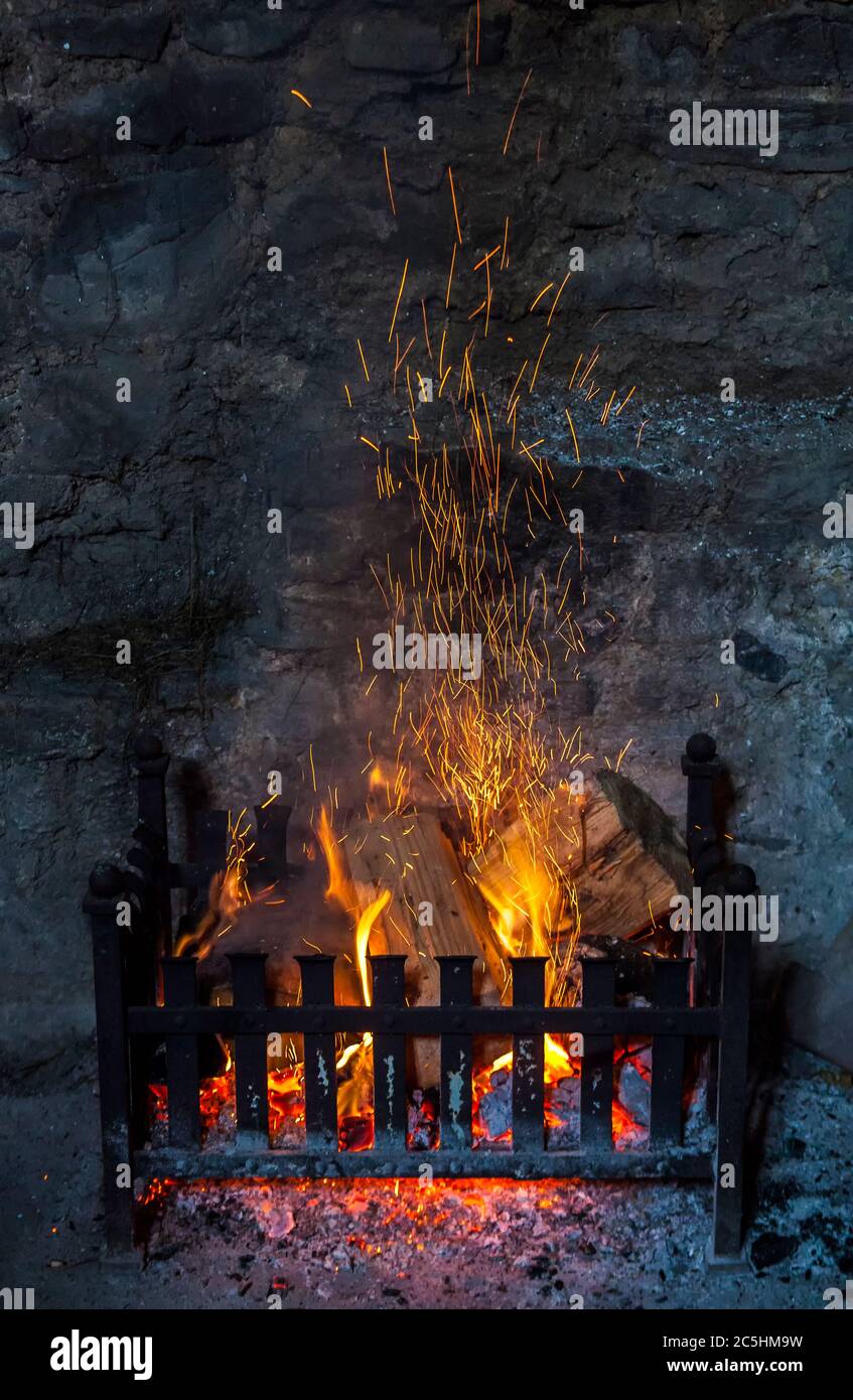 Old fashioned open log fireplace in with flames and sparks Stock Photo ...