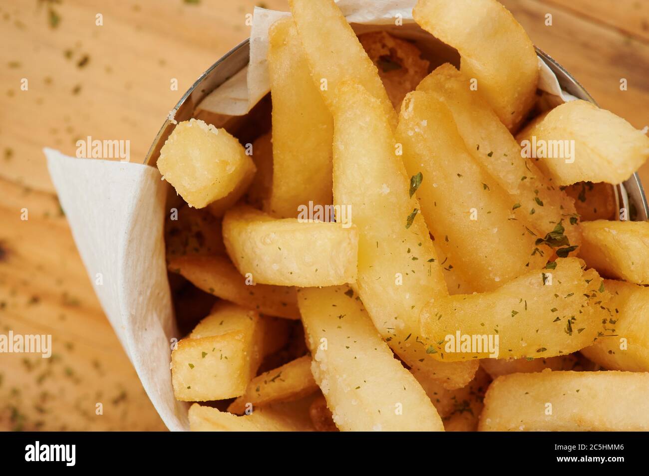 Crispy french fries in cup on wooden table close up view Stock Photo ...