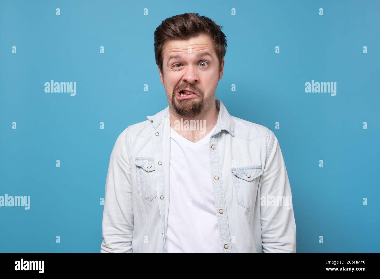 Crazy looking man making funny faces squinting eyes Stock Photo - Alamy