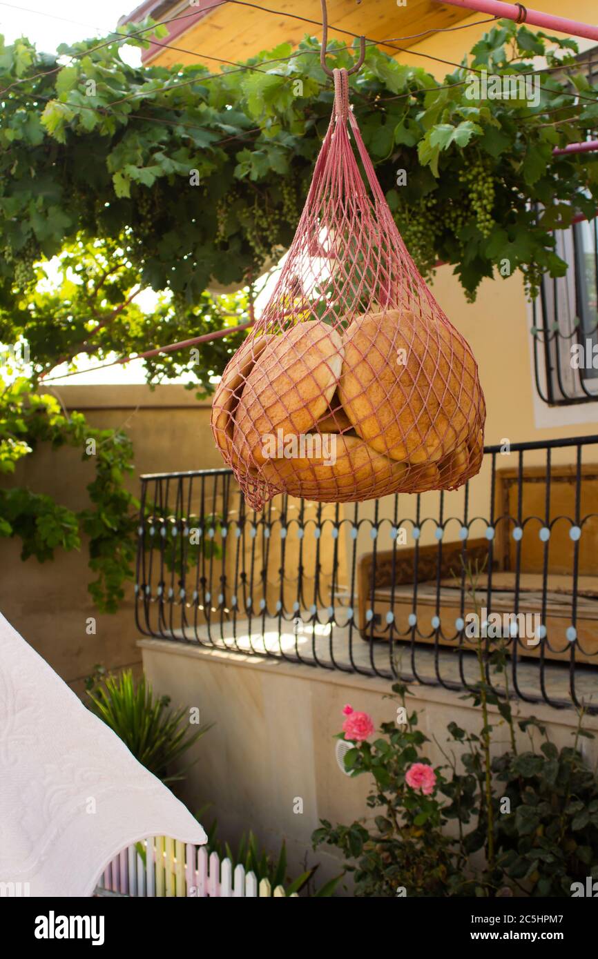 Round white bread hanging in a grid for drying Stock Photo - Alamy
