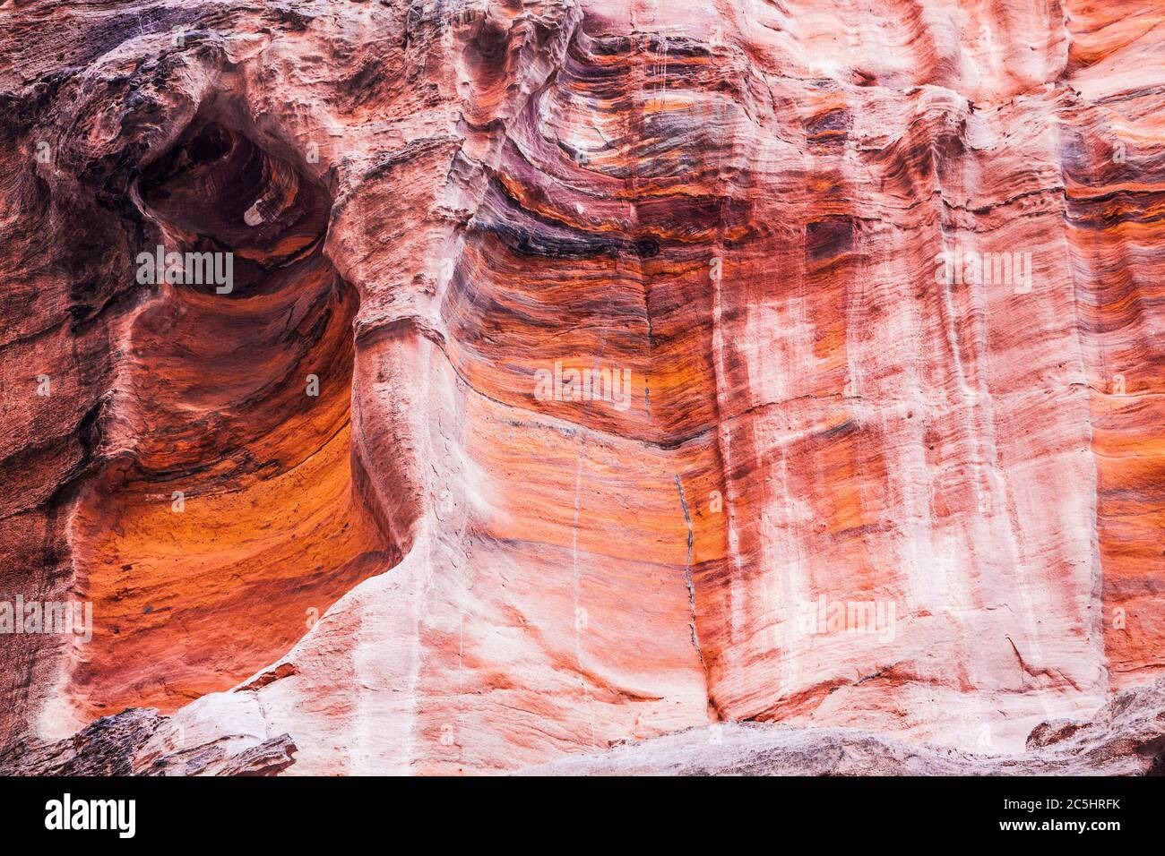 The red sandstone rock surface of the canyon known as Al Siq at the ...