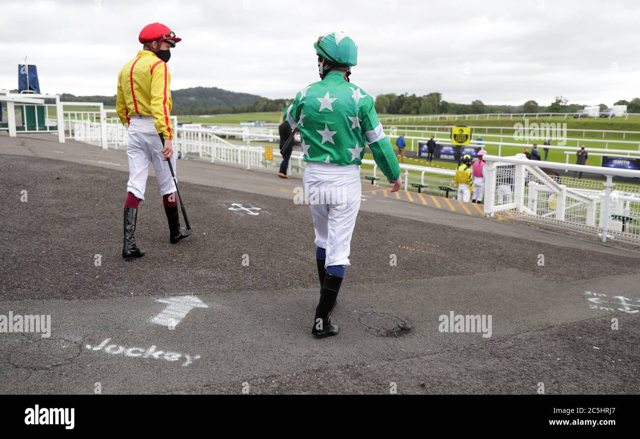 Jockeys make their way to the parade ring for the ownersgroup.co.uk ...