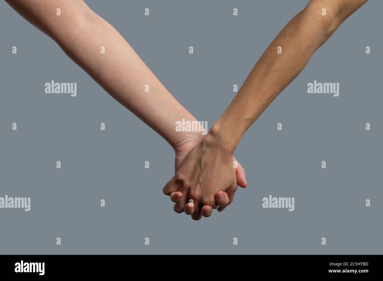 Close-up of light-skinned and dark-skinned people holding hands Stock ...