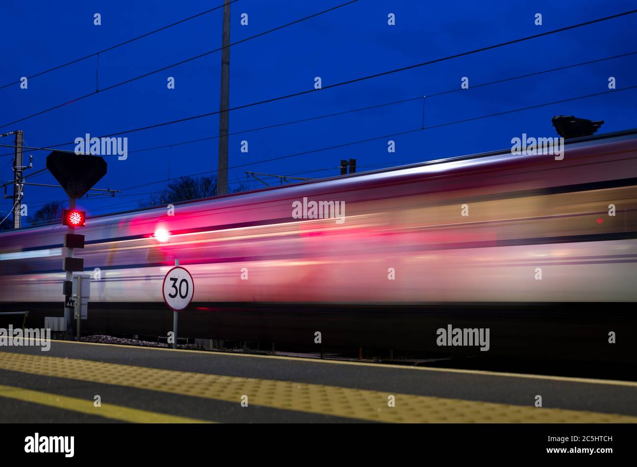 LNER high speed train sppeding through a railway station on the east ...