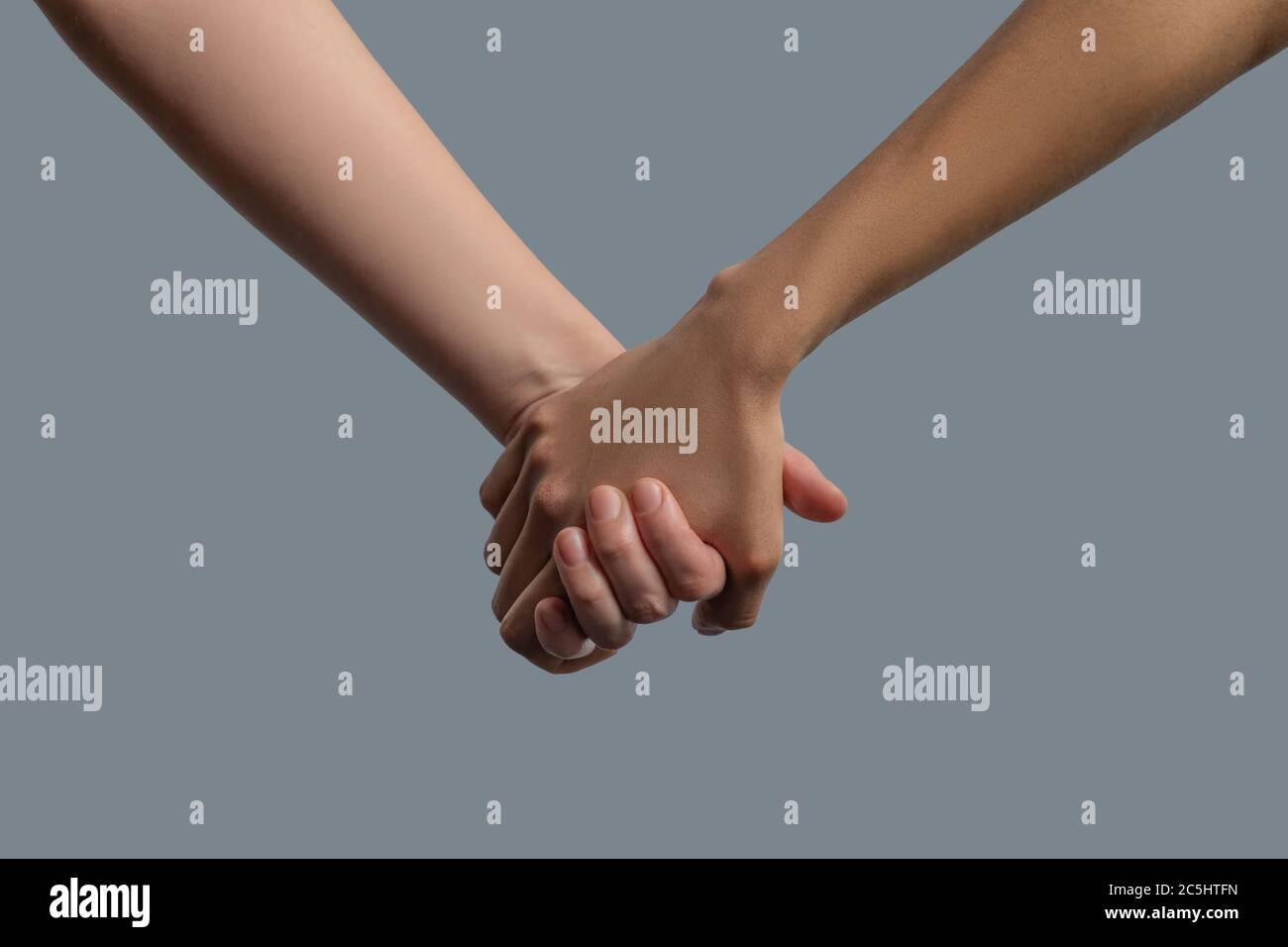 Close-up of light skinned and dark skinned people holding hands Stock ...