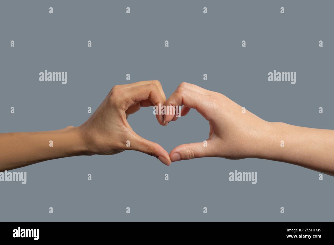 Close-up of light-skinned and dark-skinned hands shaping in heart Stock ...