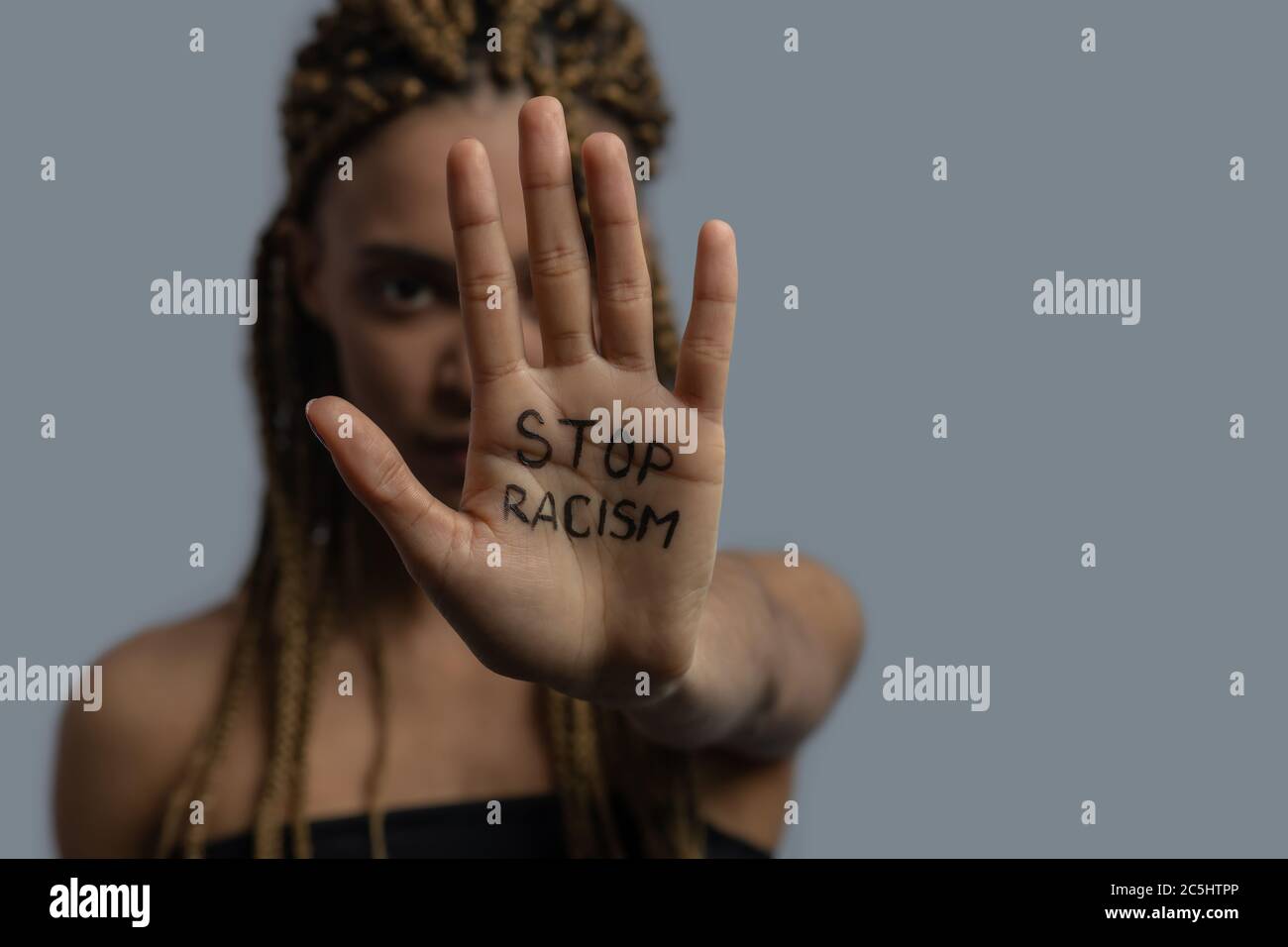 Young African American woman showing palm with stop racism lettering ...