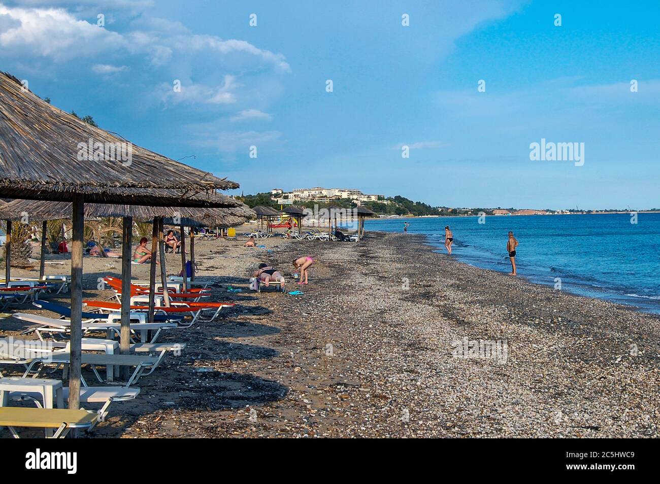 Greek beach on the Aegean Sea in the early morning. The sun has just ...