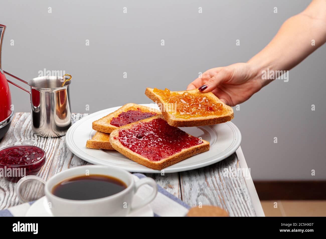 Female hands preparing toasts with fruit jam Stock Photo - Alamy