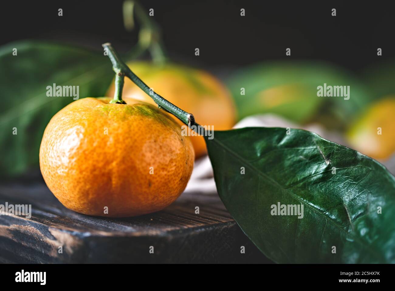 Tangerines with leaves on an old fashioned country table. Selective ...