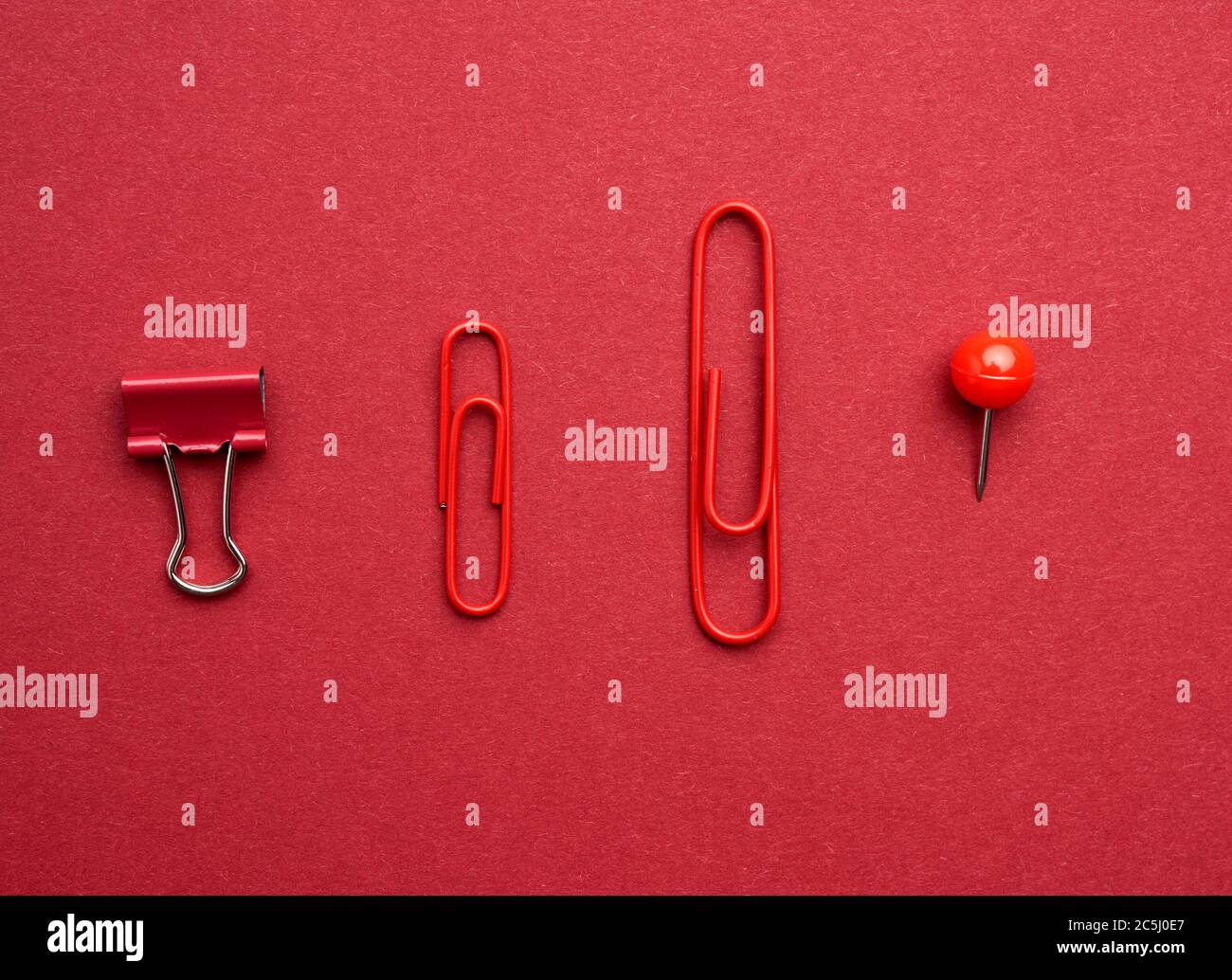 red metal paper clips, button on a red background, top view Stock Photo ...