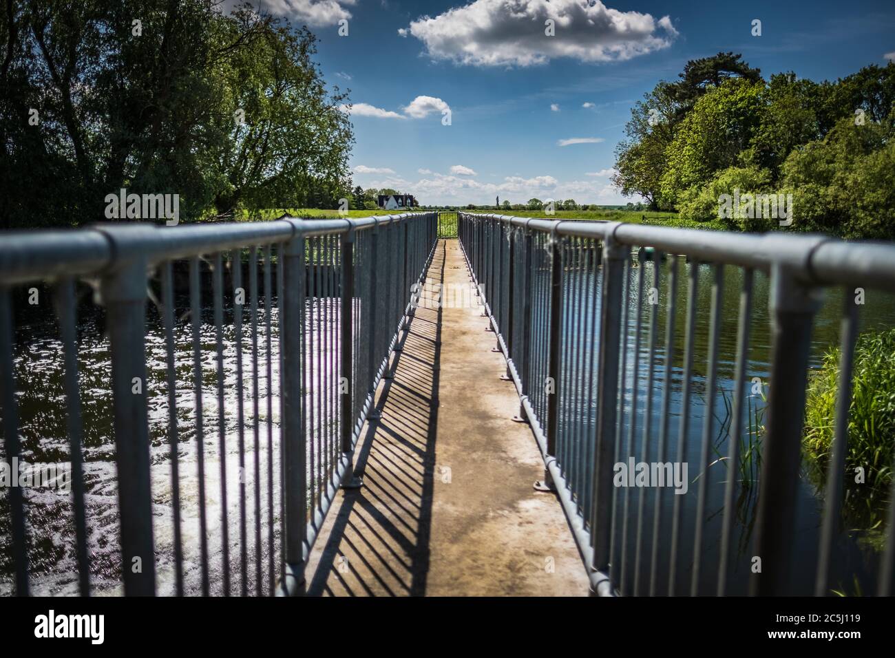 High contrast, shallow focus of a narrow footbridge seen crossing a ...