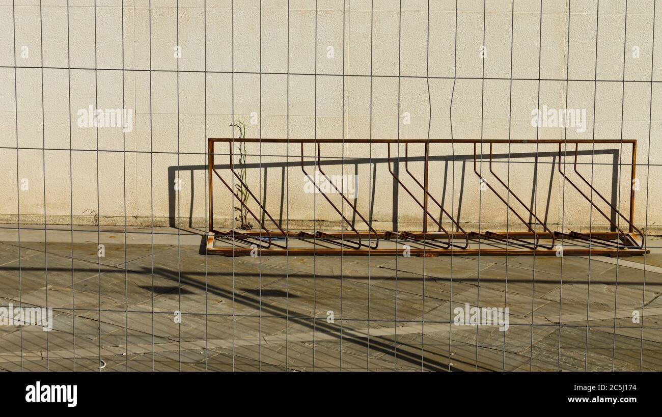 Rusted bicycle rack behind a metallic fence (Pesaro, Italy, Europe ...