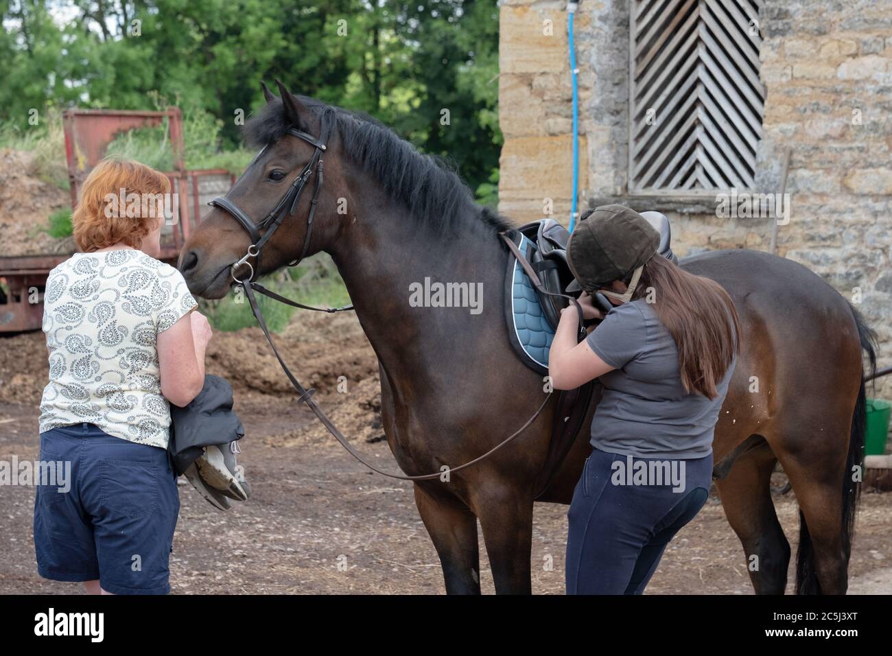 Young female student seen preparing to ride a New Forest pony at a ...