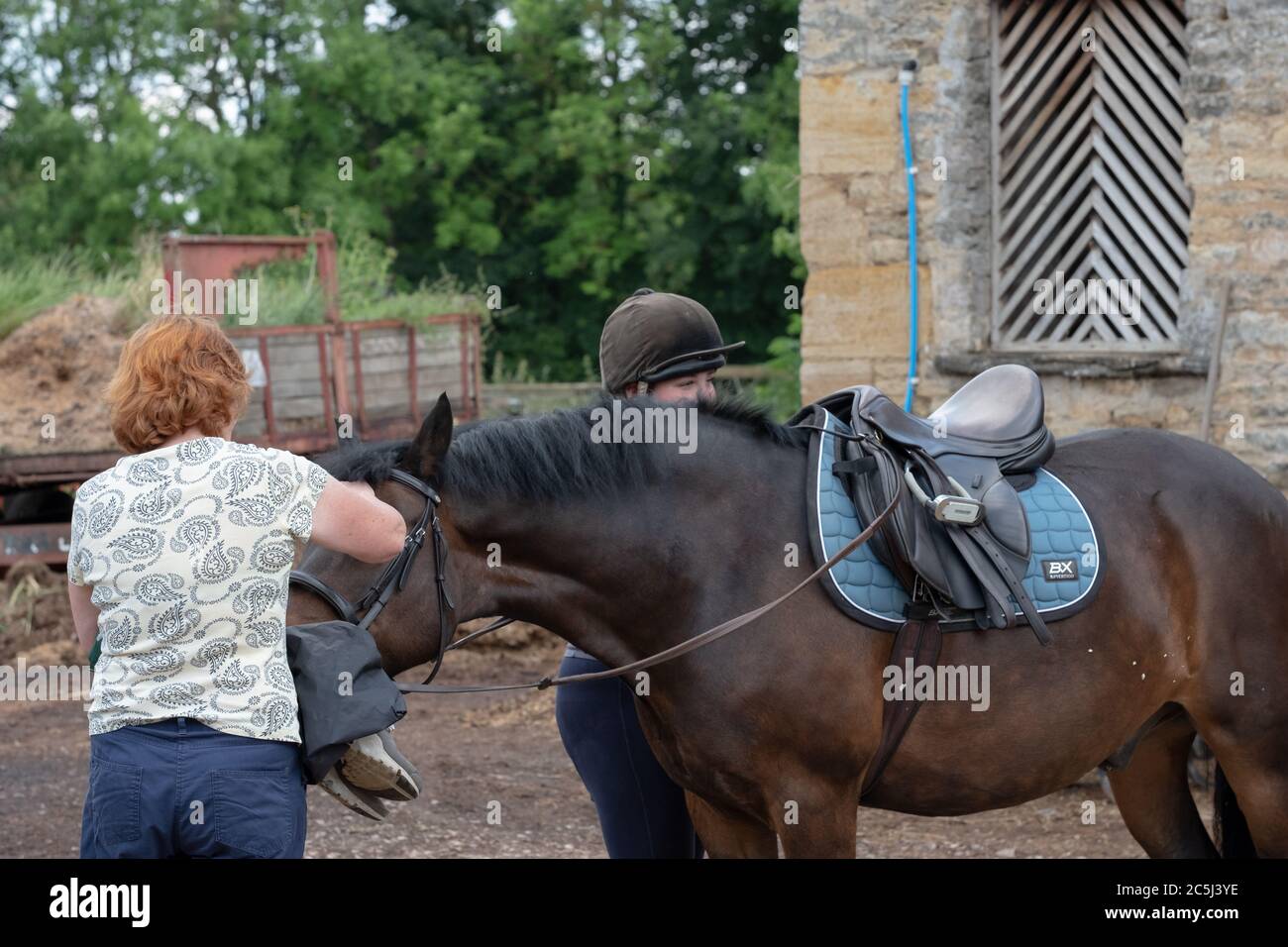 Young female student seen preparing to ride a New Forest pony at a ...