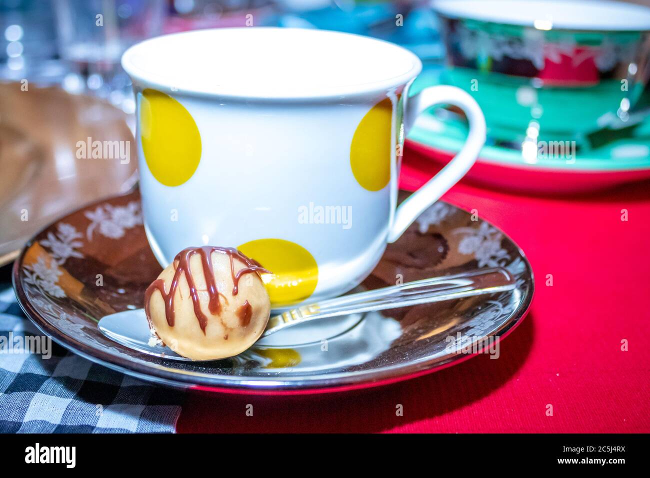 Colorful Tea party with cup of tea in a yellow spotted teacup and sweet ...
