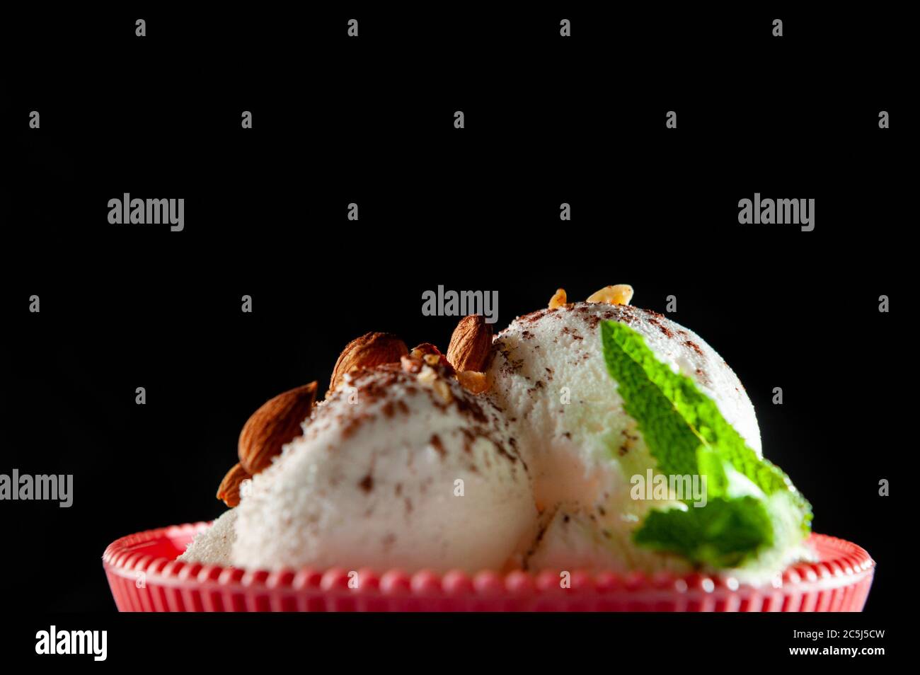 balls of ice cream white filling on a black background with mint and ...
