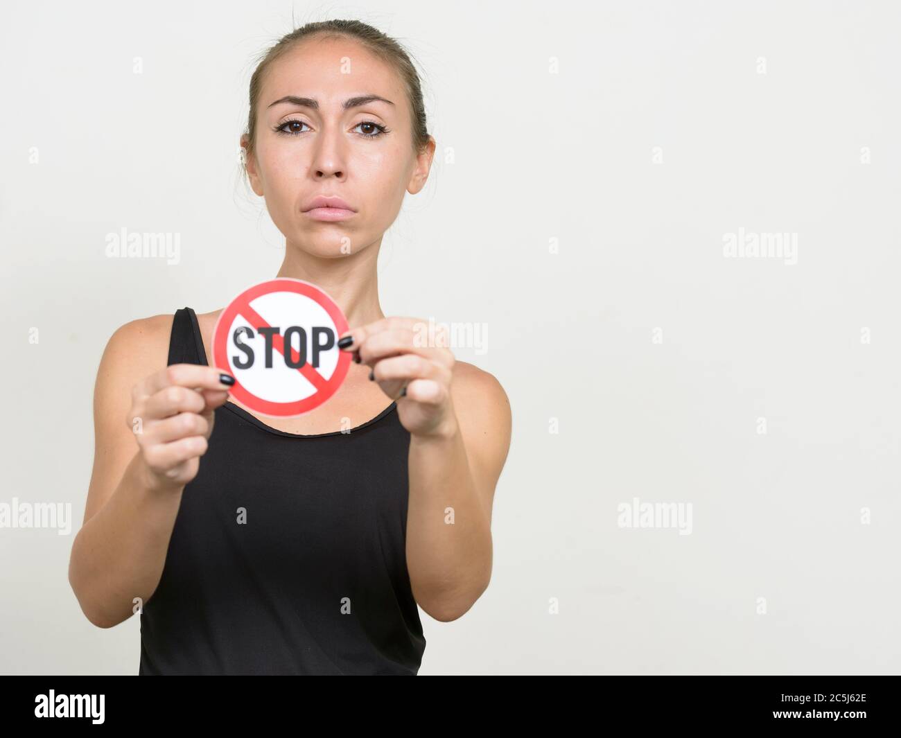 Young woman with brown hair showing stop sign Stock Photo - Alamy