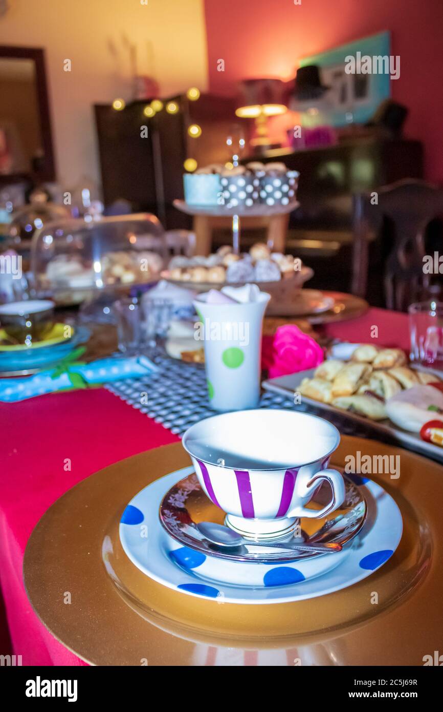Colorful Tea party with table laid out fancy tea cups and saucers, with ...