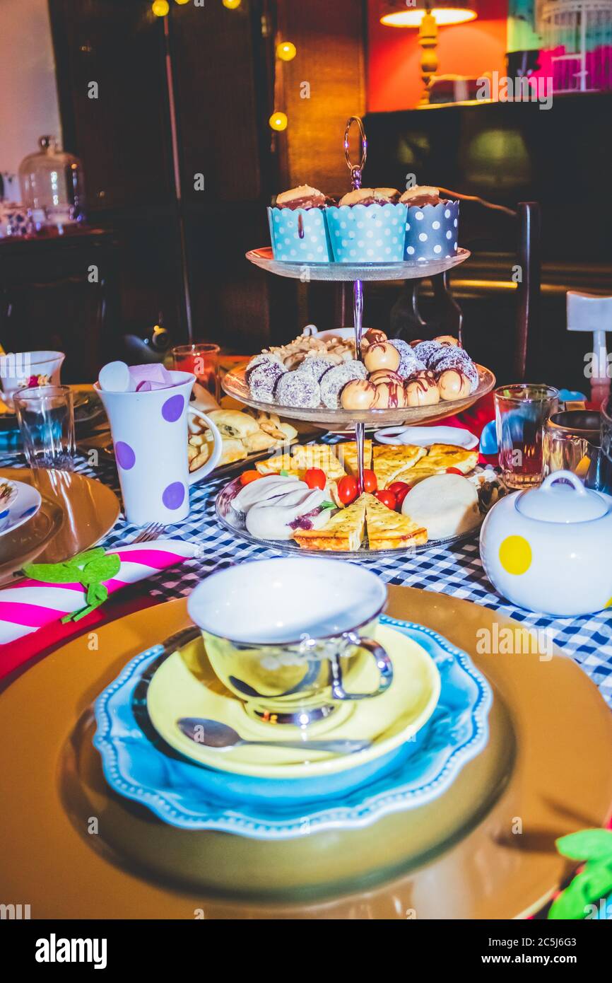 Colorful Tea party with table laid out fancy tea cups and saucers, with ...