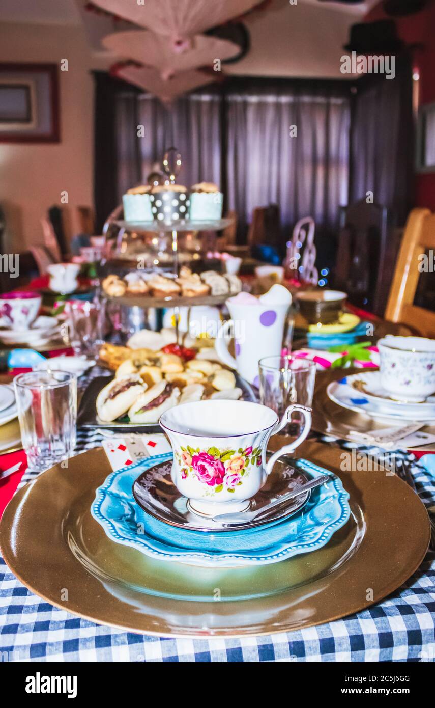 Colorful Tea party with table laid out fancy tea cups and saucers, with ...