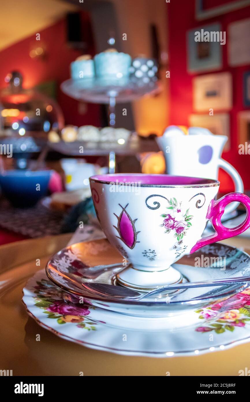 Colorful Tea party with table laid out fancy tea cups and saucers, with ...