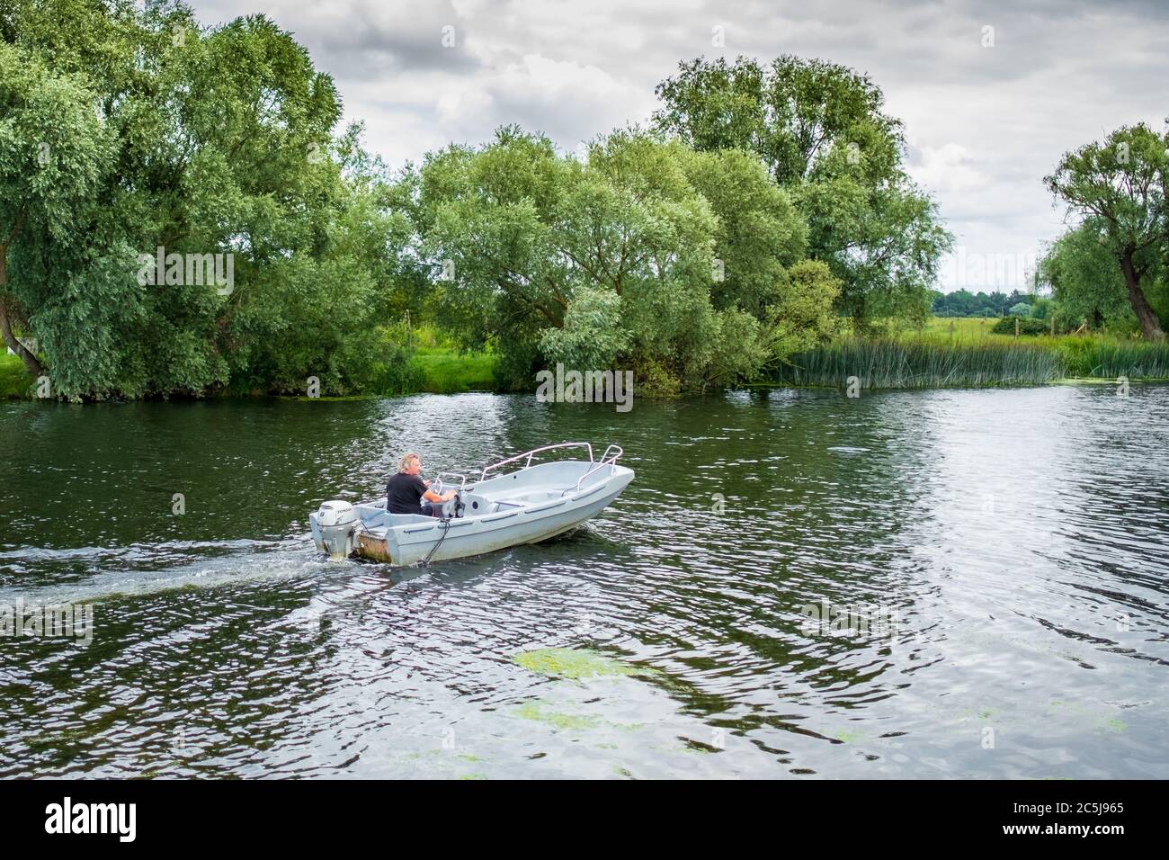 Small, motor boat seen on an inland waterway with a single person ...