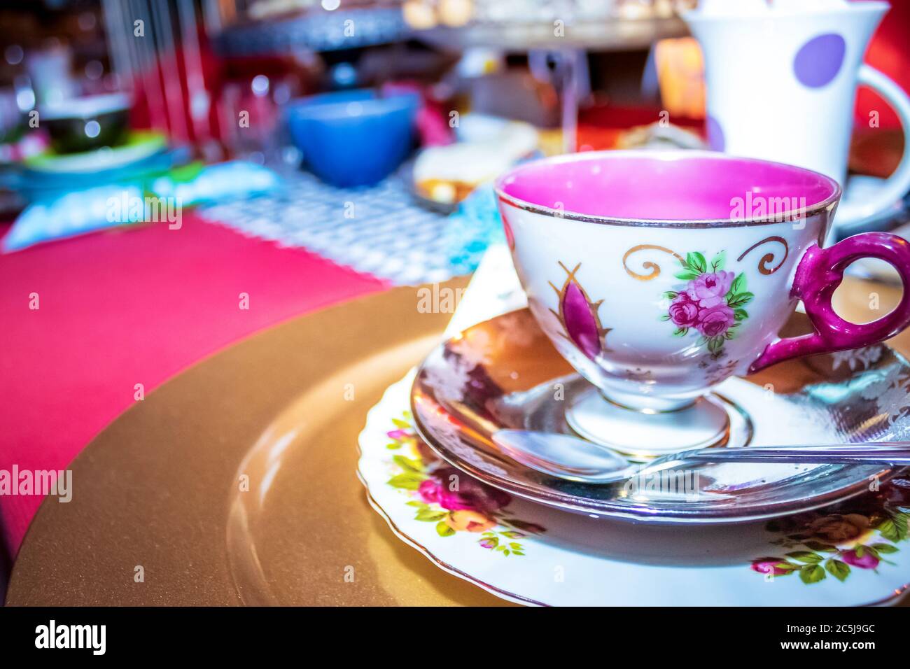 Colorful Tea party with table laid out fancy tea cups and saucers, with ...