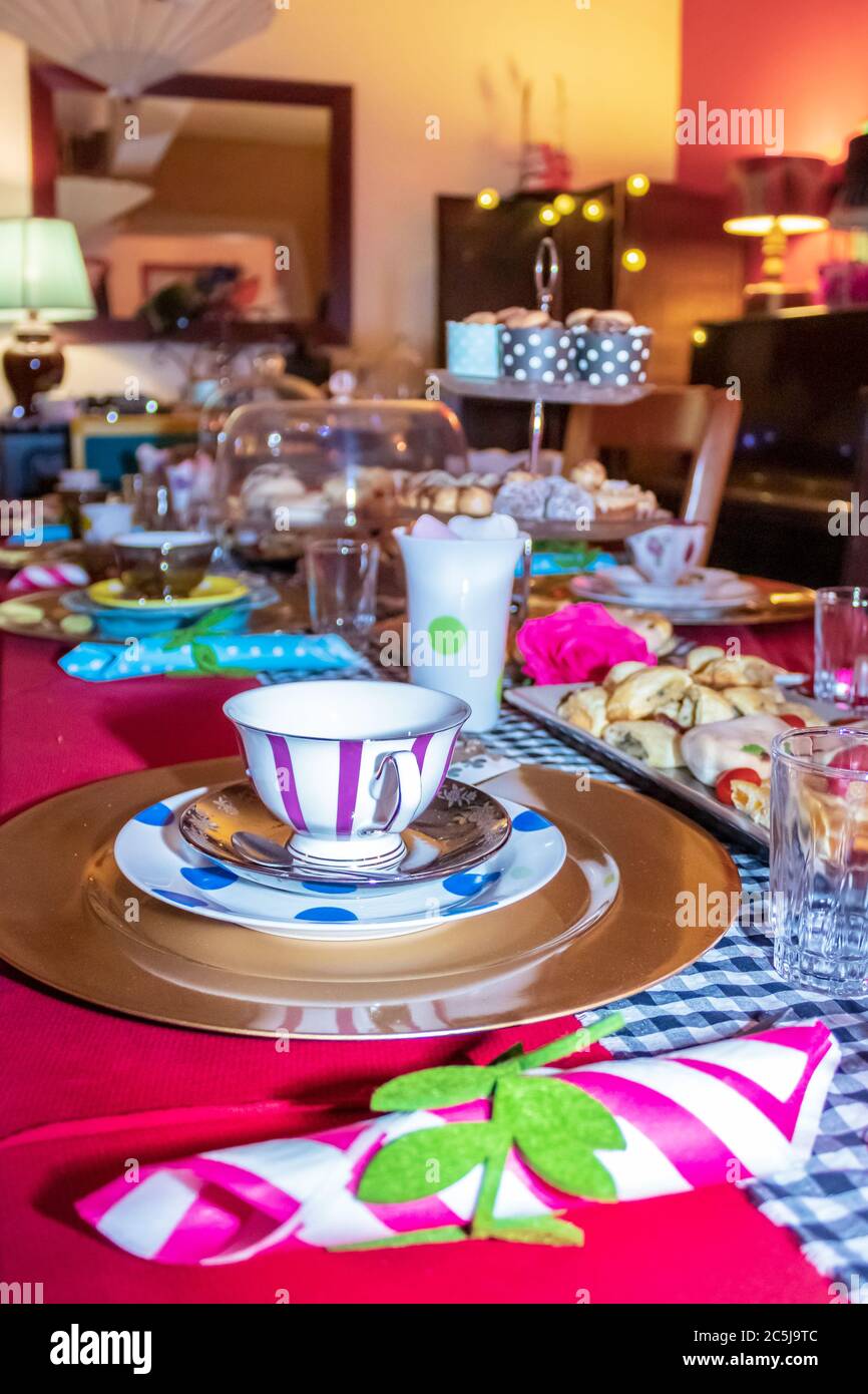 Colorful Tea party with table laid out fancy tea cups and saucers, with ...