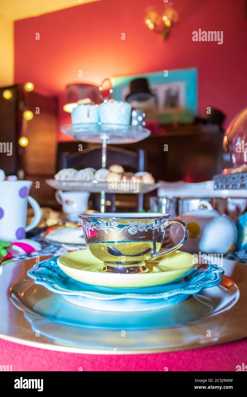 Colorful Tea party with table laid out fancy tea cups and saucers, with ...