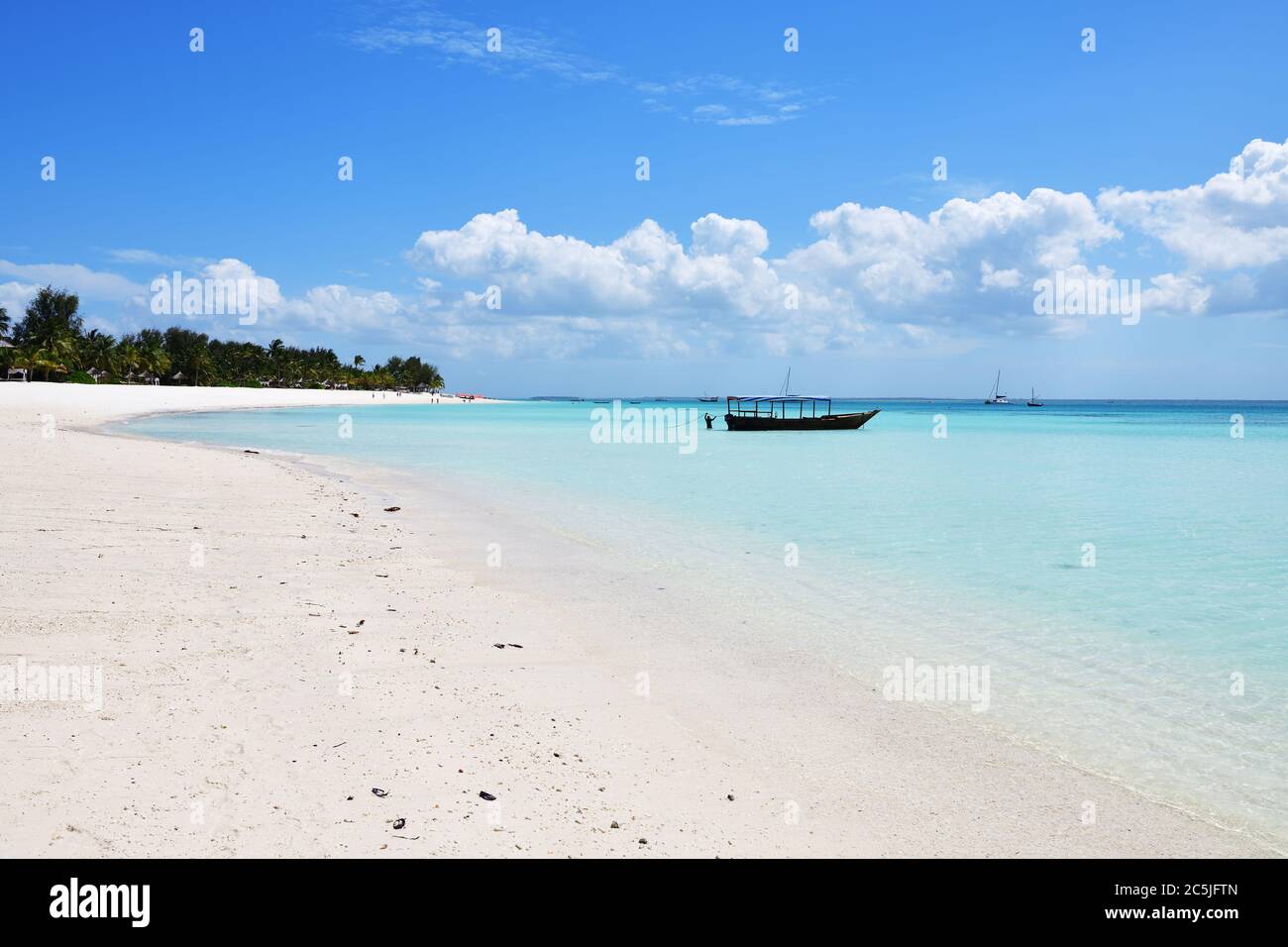 Blue transparent water and fishing boat moored in Indian ocean, Kendwa ...