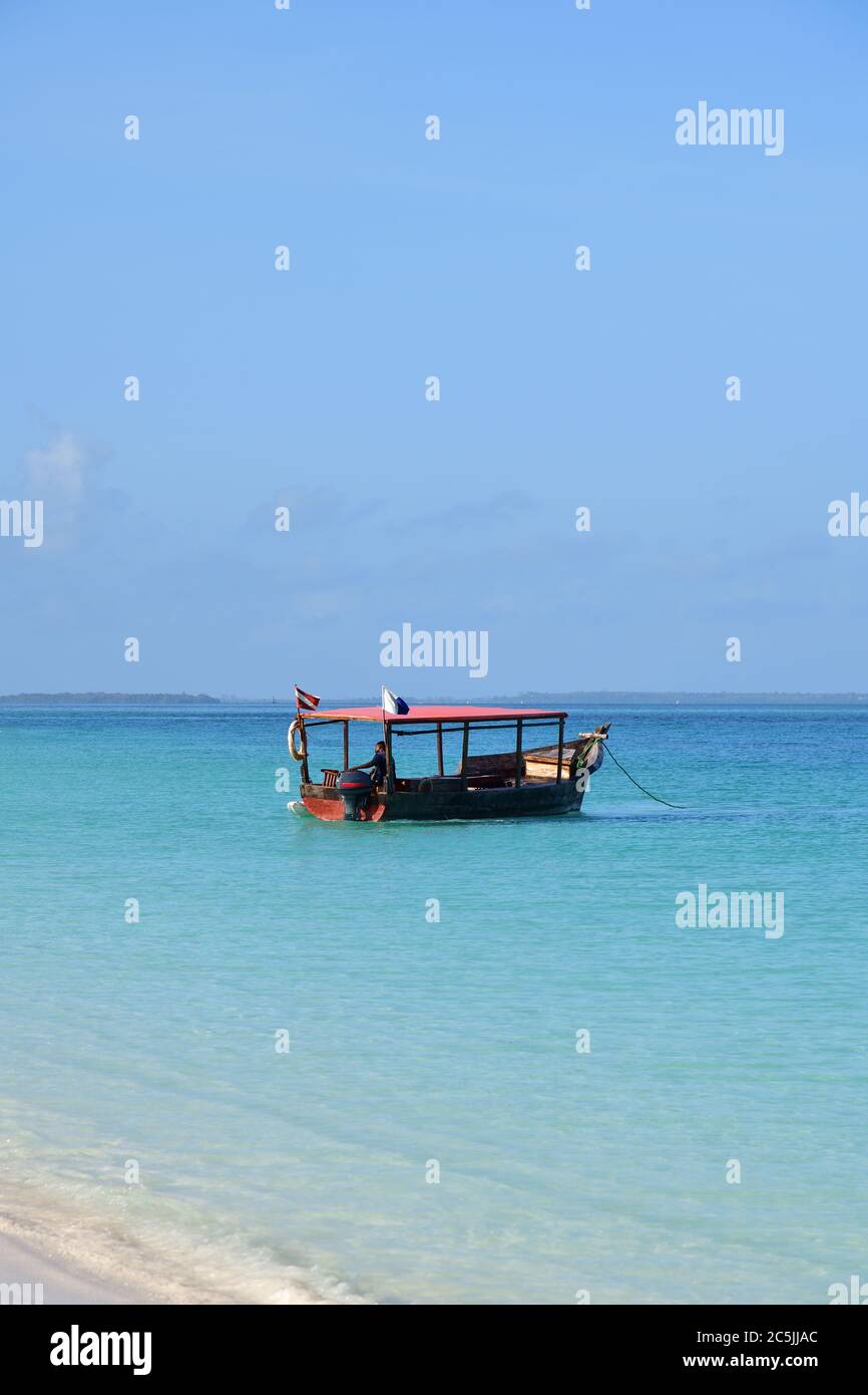 Blue transparent water and motor fishing boat moored on Indian ocean ...