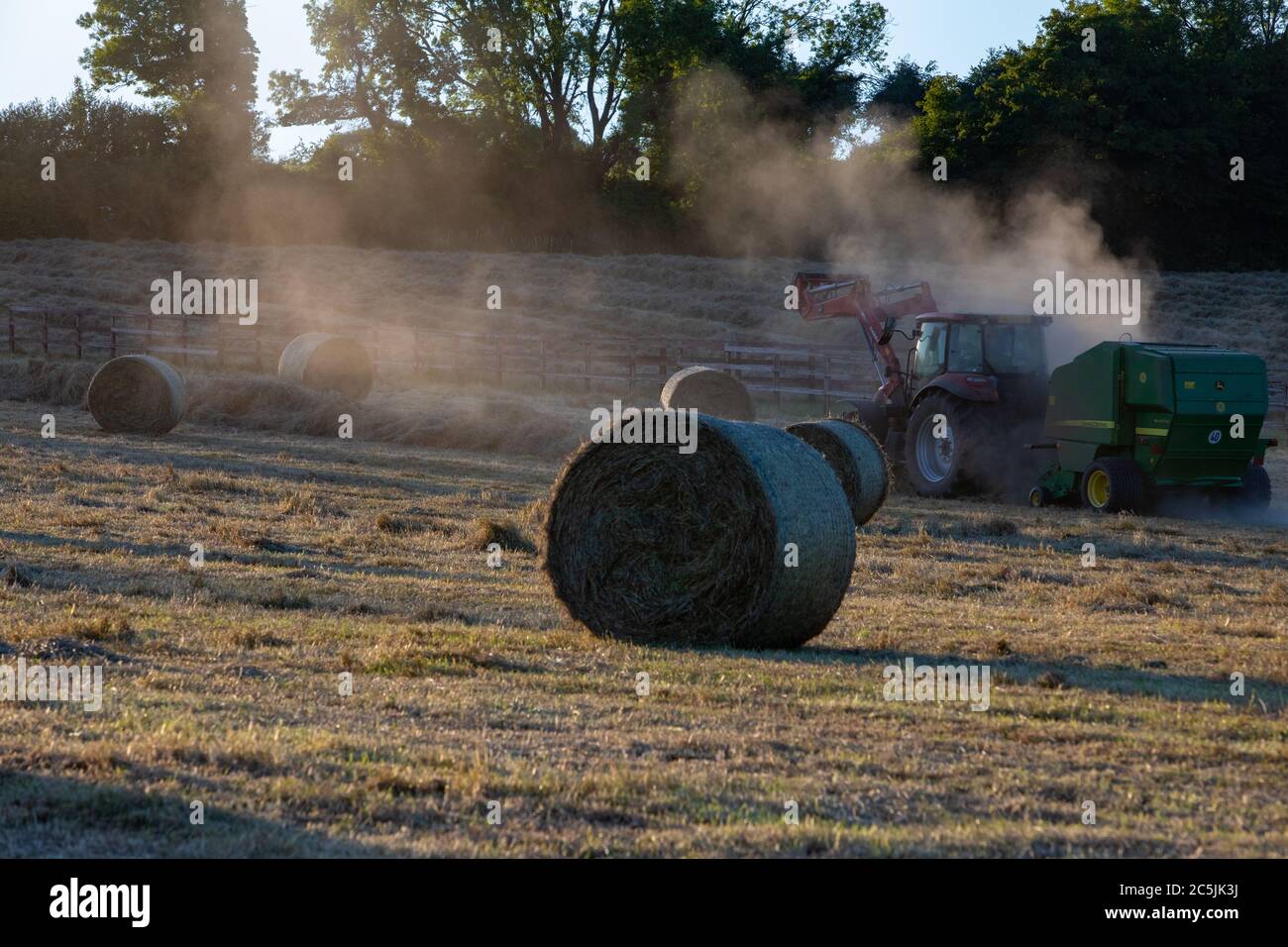 Hay Harvest June 2020 UK red tractor, sunset baling the hay. large ...