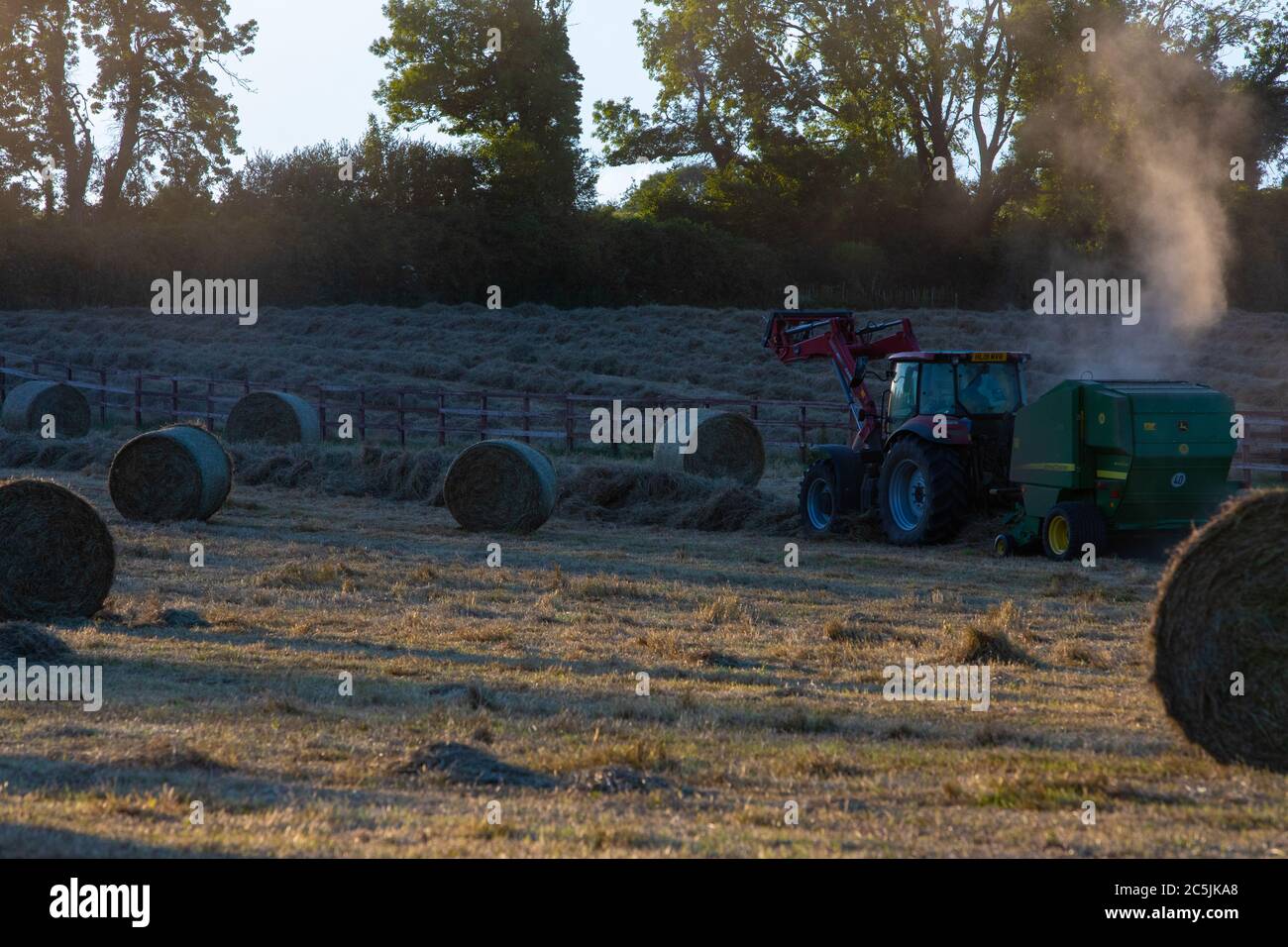 Hay Harvest June 2020 UK red tractor, sunset baling the hay. large ...
