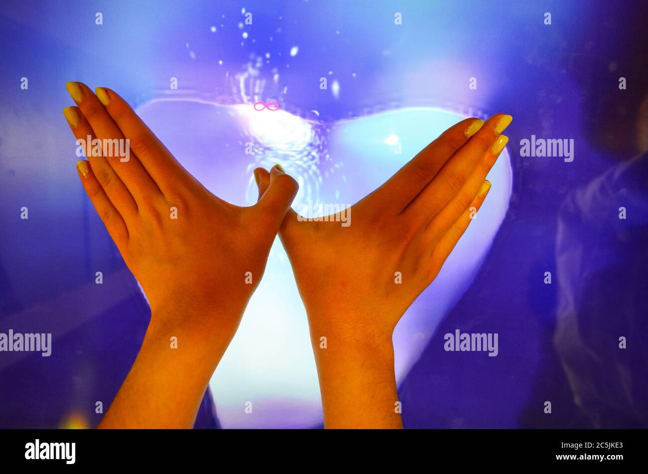 Young girl's hands playing over big blue touch screen with sign of ...