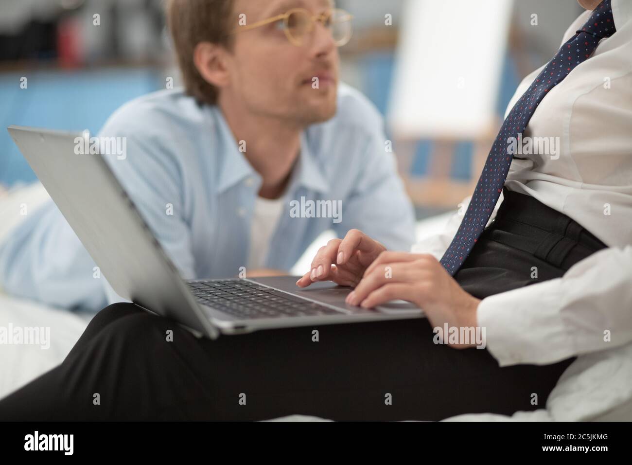 Man laying near his wife while she is working. Close up shot of ...