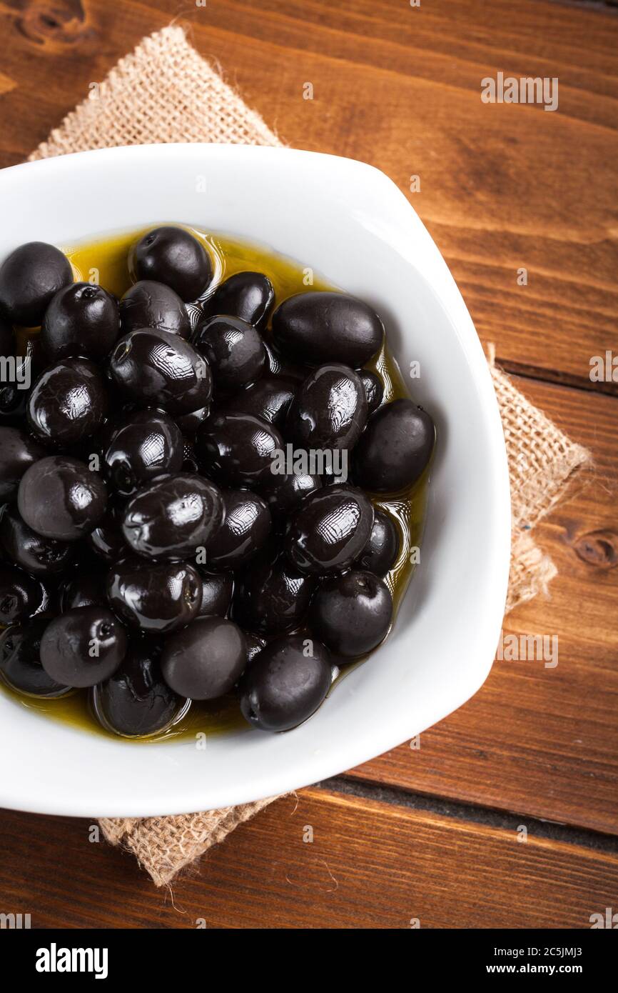 Black olives on rustic table from Apulia region, Italy Stock Photo - Alamy