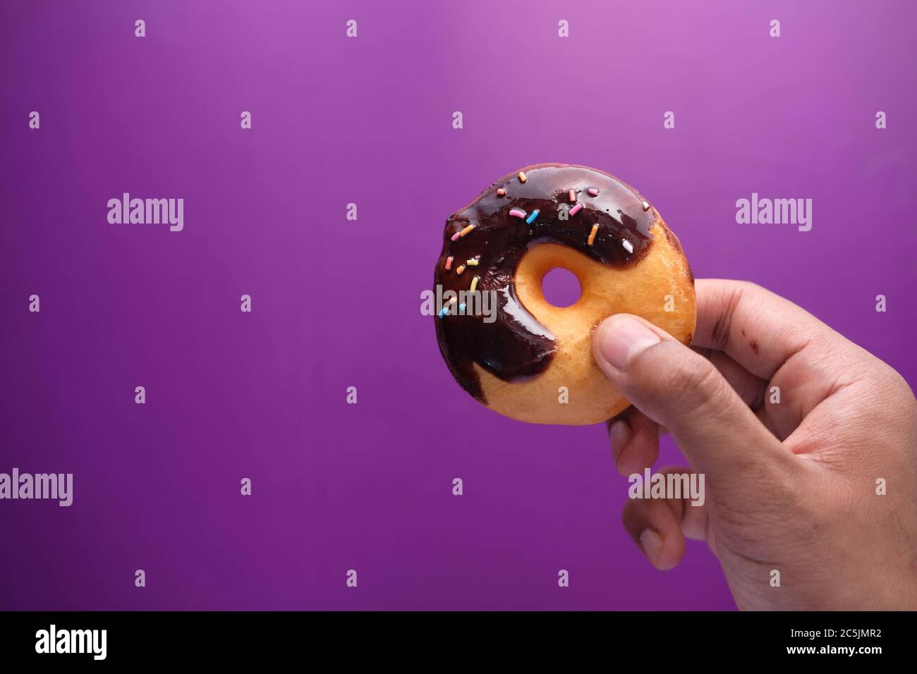 Close up of hand holding donuts Stock Photo - Alamy