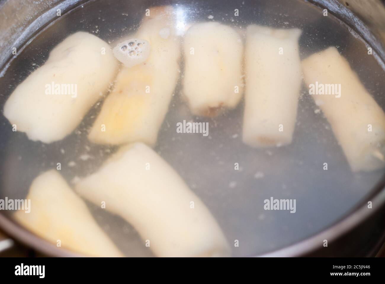 cooking cassava in a pot with boiling water, Manihot esculenta ...