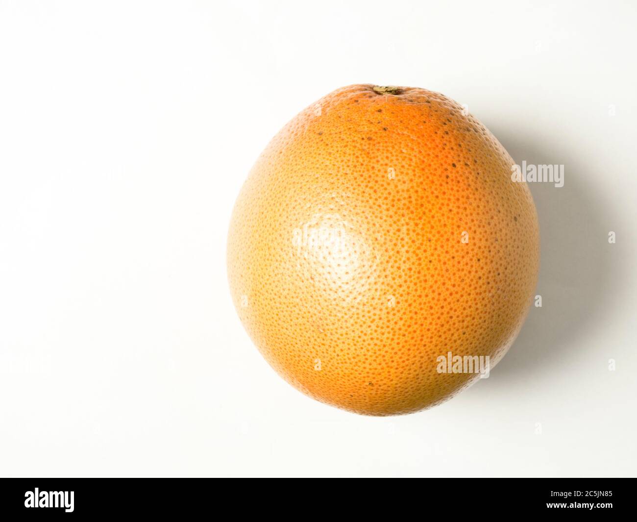 A whole pink grapefruit isolated on a white background with copy space ...