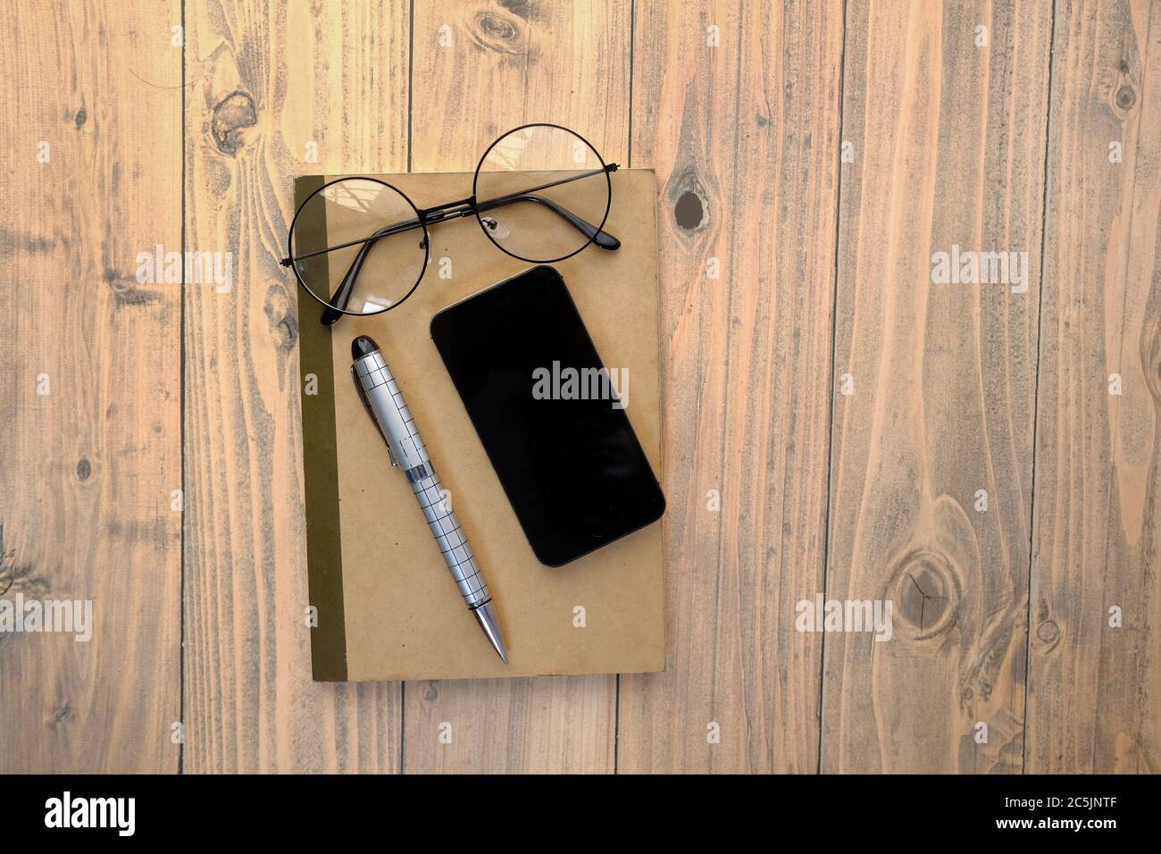 smart phone with empty screen, notepad on wooden table Stock Photo - Alamy