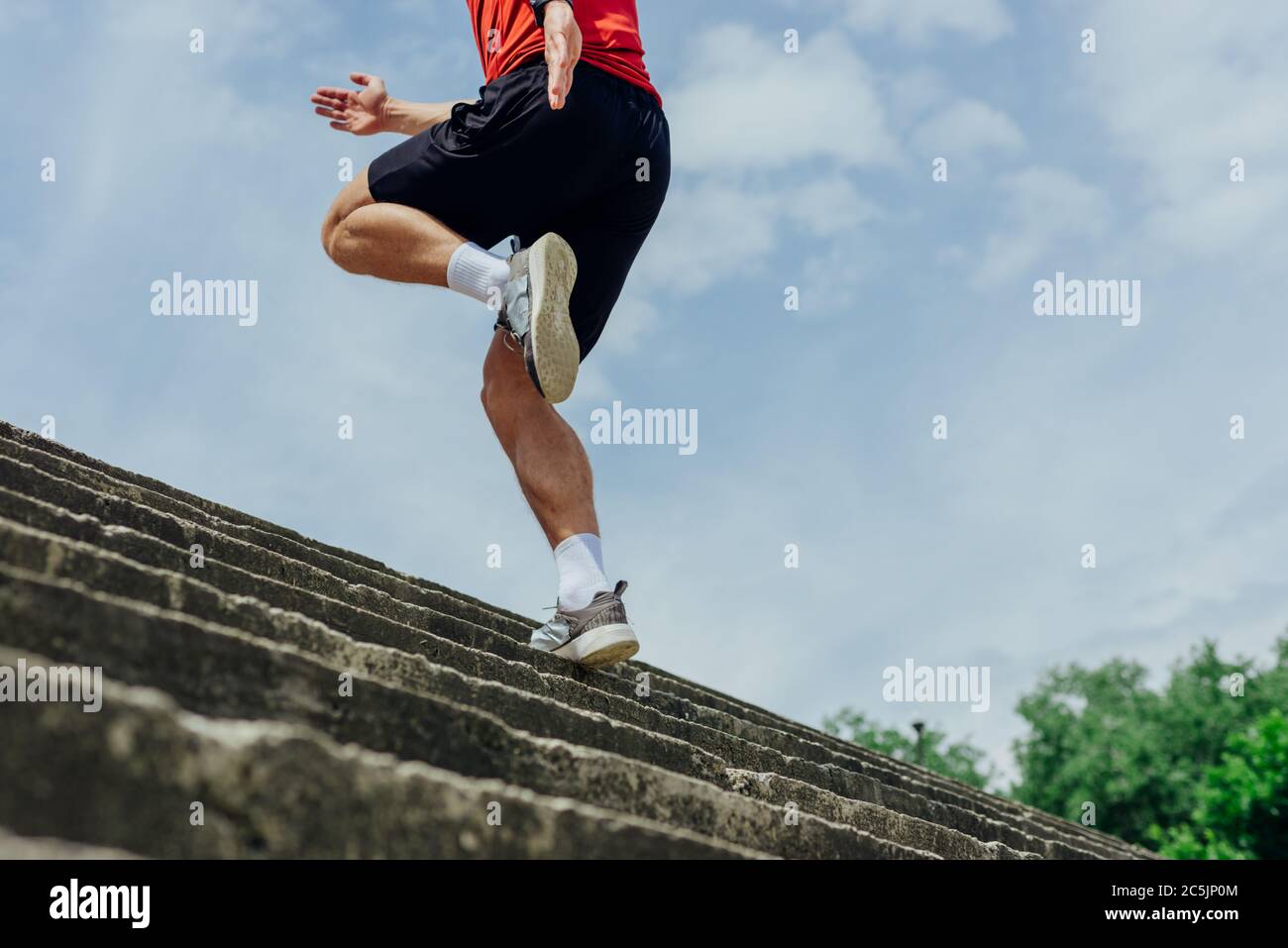 Fit male athlete performing stairs workout, running up climbing stairs ...