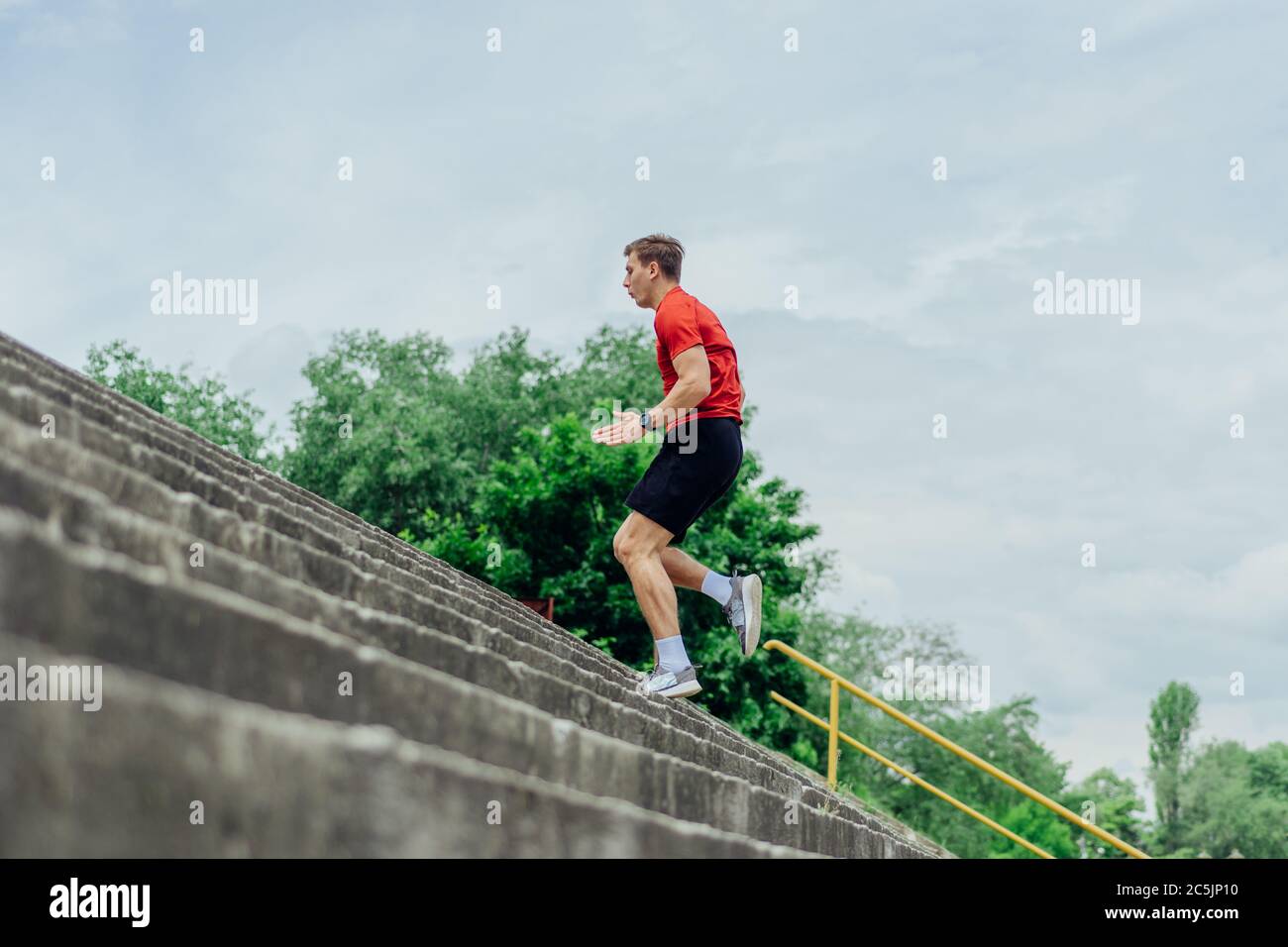 Fit male athlete performing stairs workout, running up climbing stairs ...