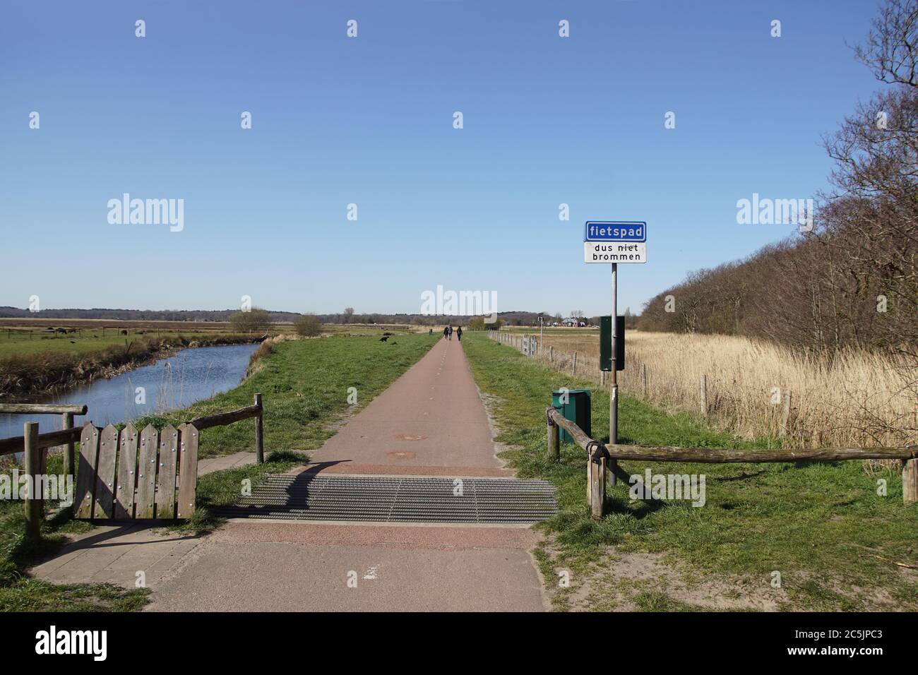 Bike path through the meadows with hikers in the distance near the ...
