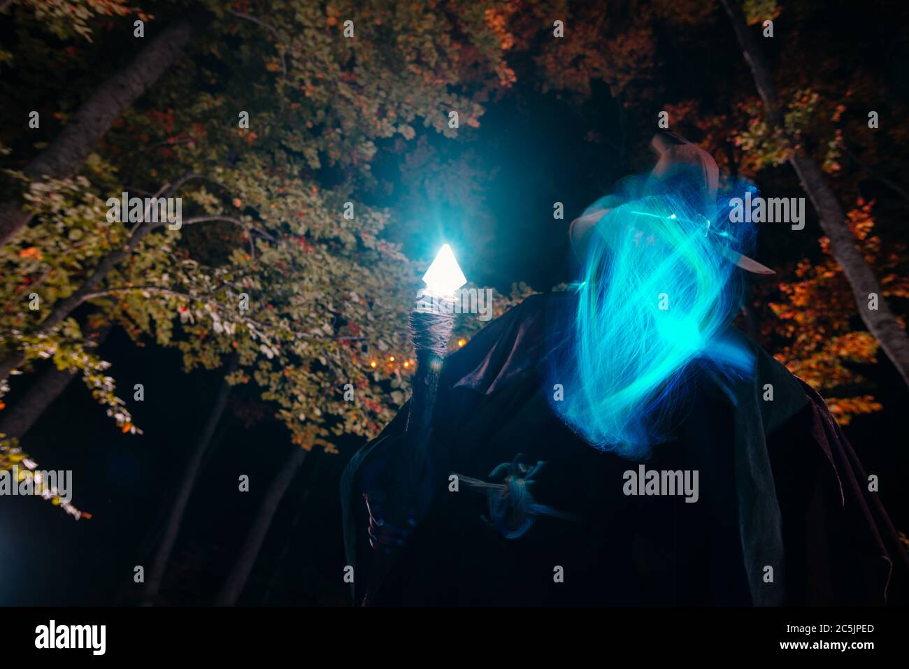 Wizard (mage) casting a spell with his magical staff while standing in ...