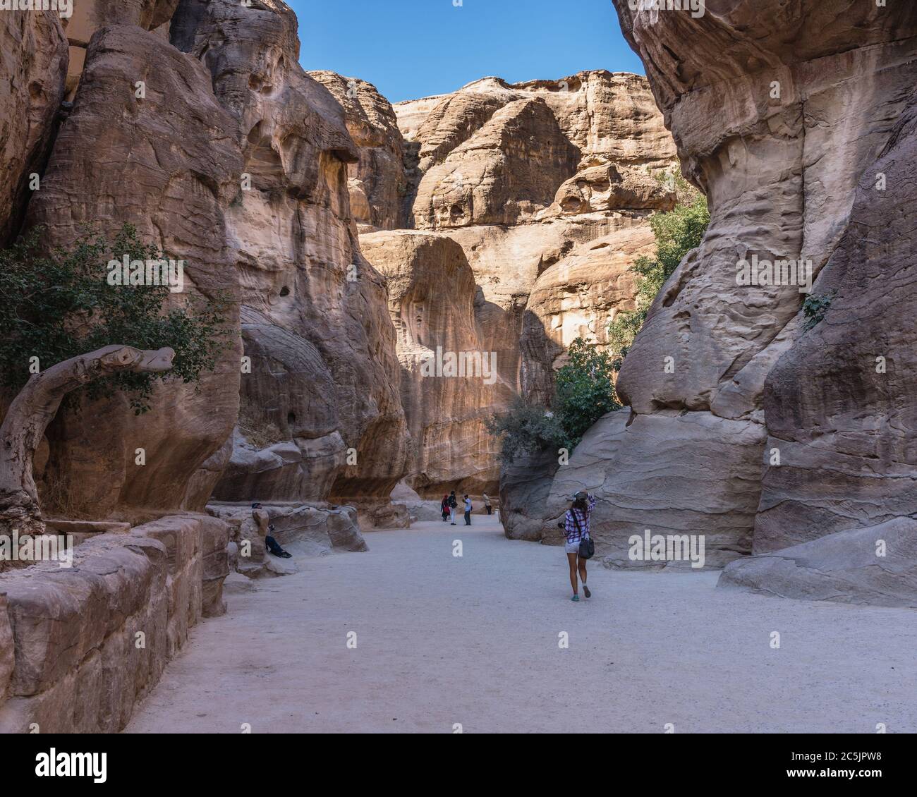 Jordan, Petra, Tourists hike into a narrow slot canyon called the Siq ...