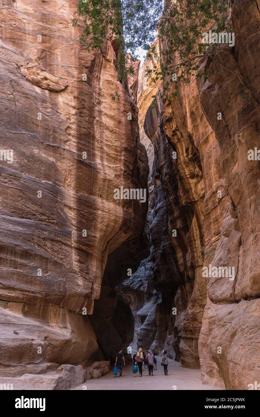 Jordan, Petra, Arab tourists hike into a narrow slot canyon called the ...