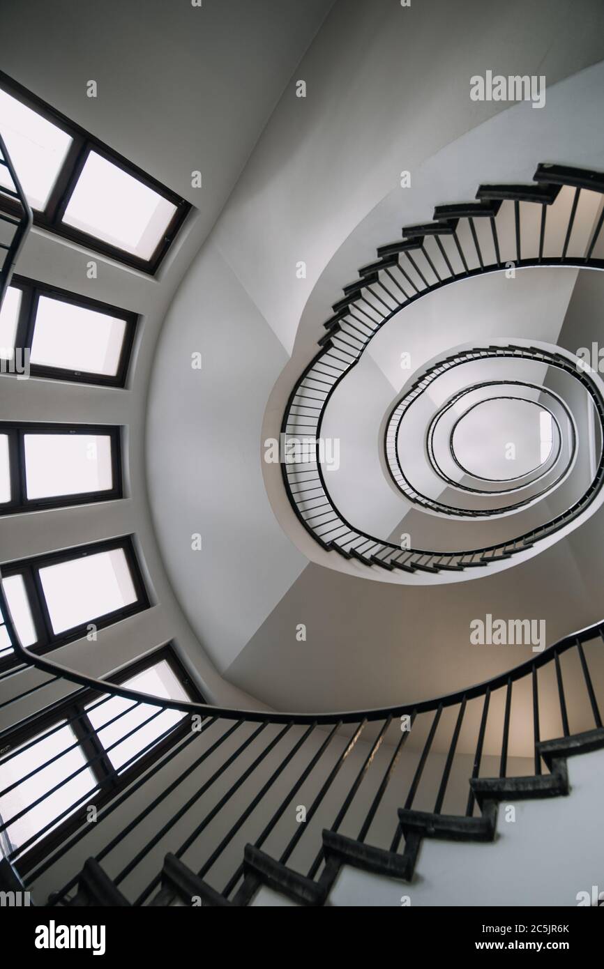 looking deep into long spiral stair case of big building, concept photo ...